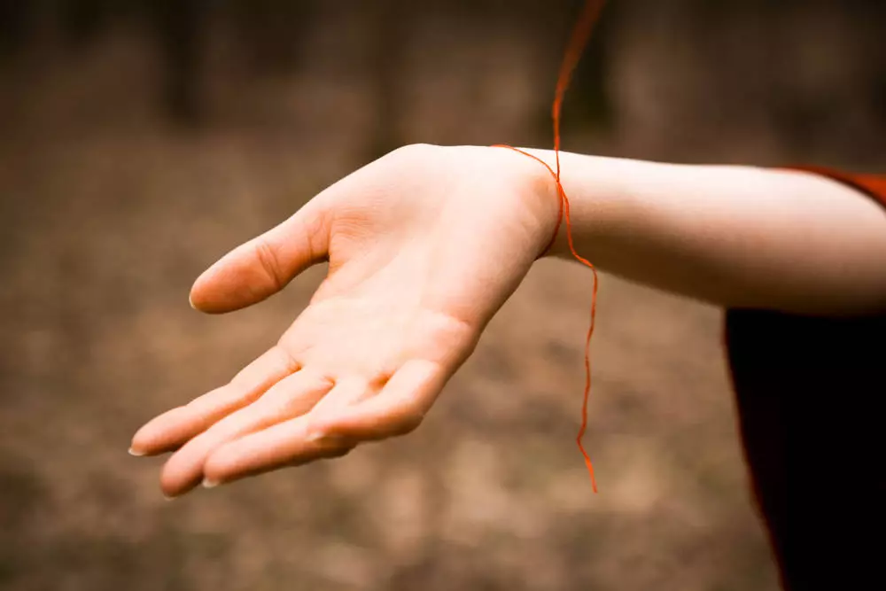 Wie bindet man einen roten Thread am Handgelenk?